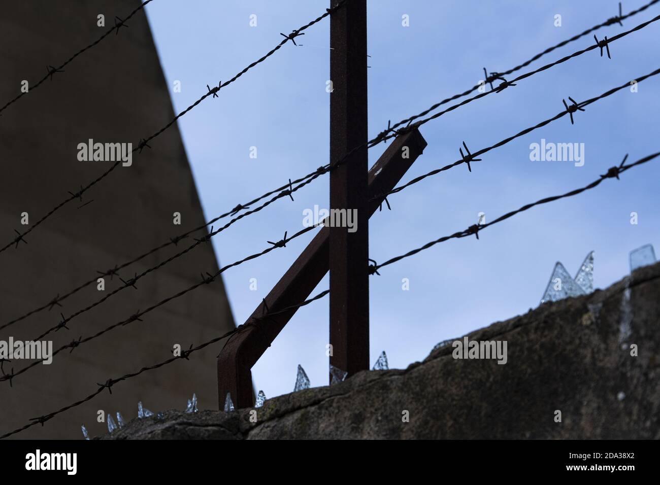Wall with barbed wire protection Stock Photo - Alamy