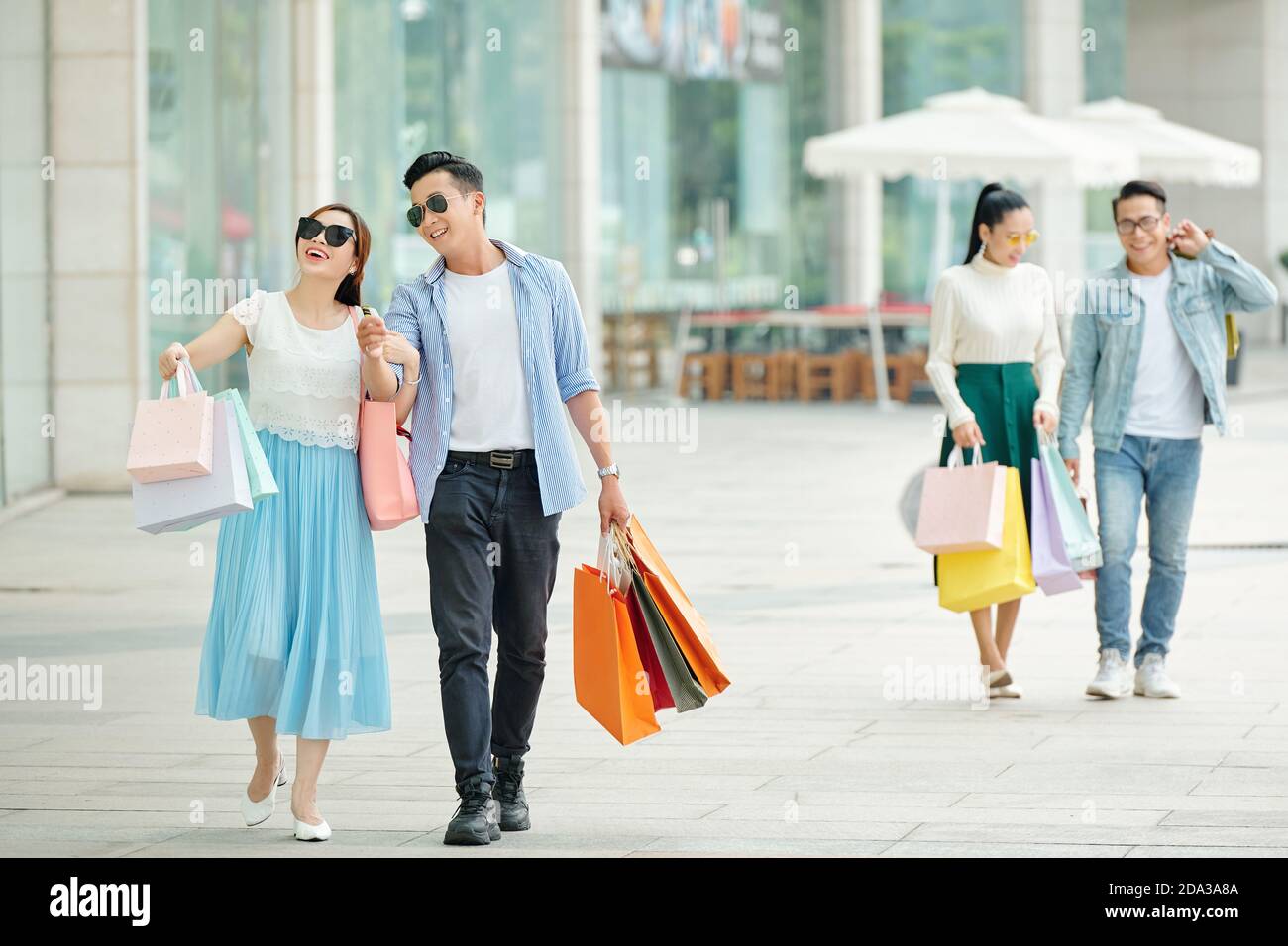 Asian couple walking in the street Stock Photo - Alamy