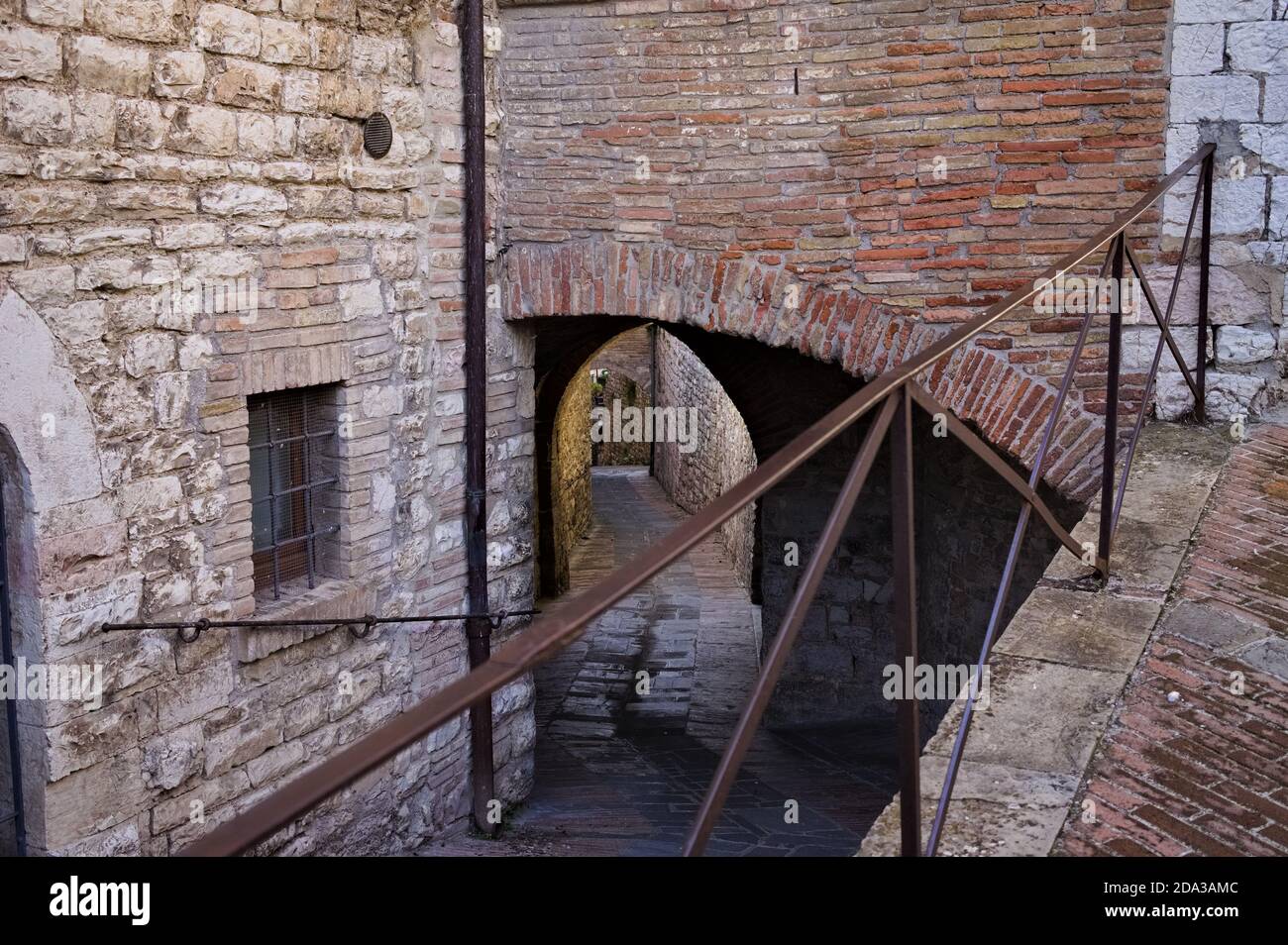 The view of an ancient alley under an architectural arch in a medieval ...
