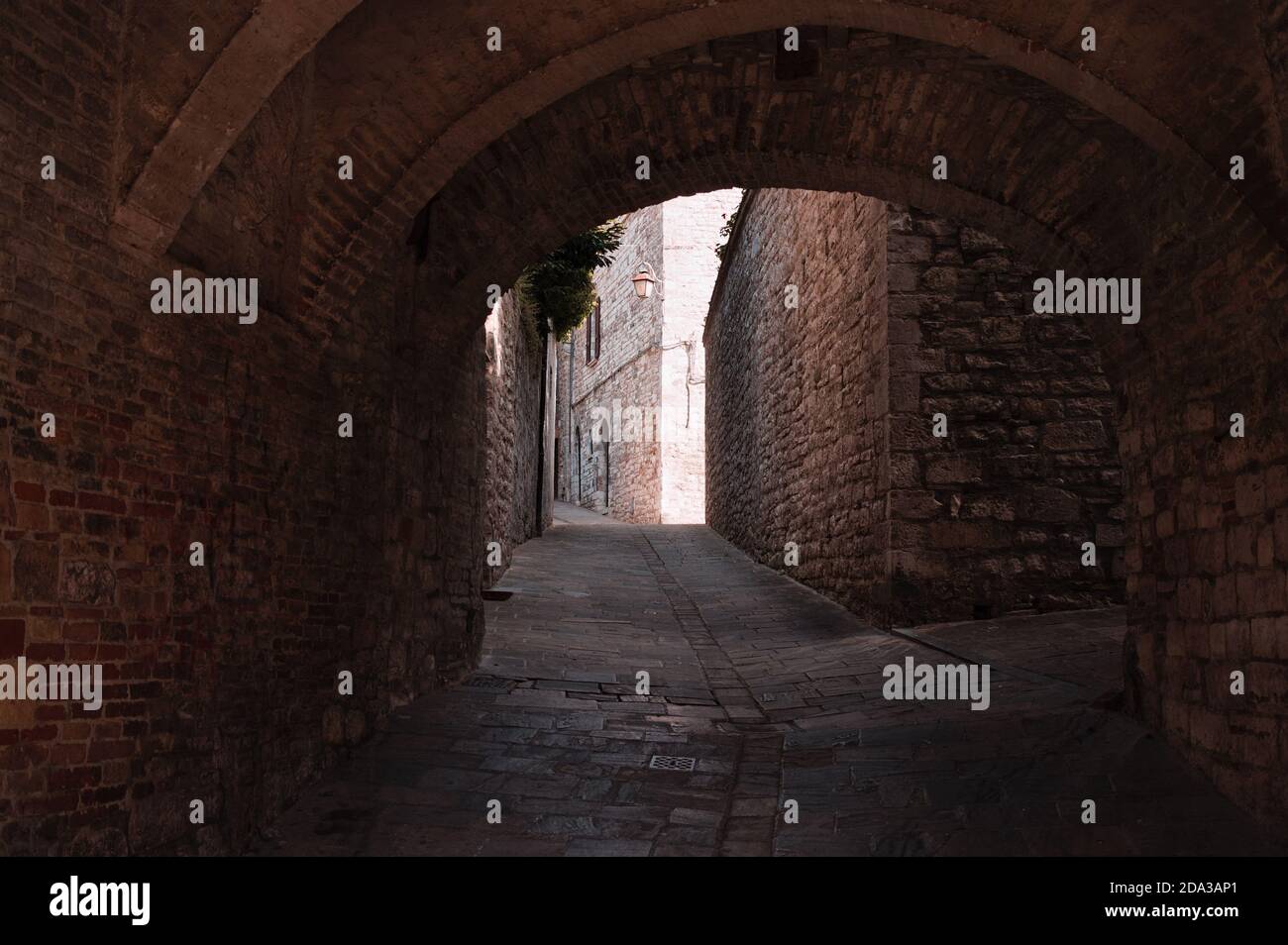 The view of an ancient alley under an architectural arch in a medieval ...