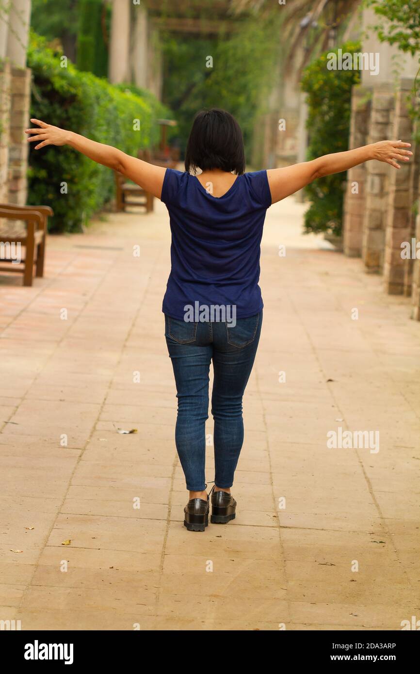 Vertical shot of a Hispanic woman standing arms up from behind Stock ...
