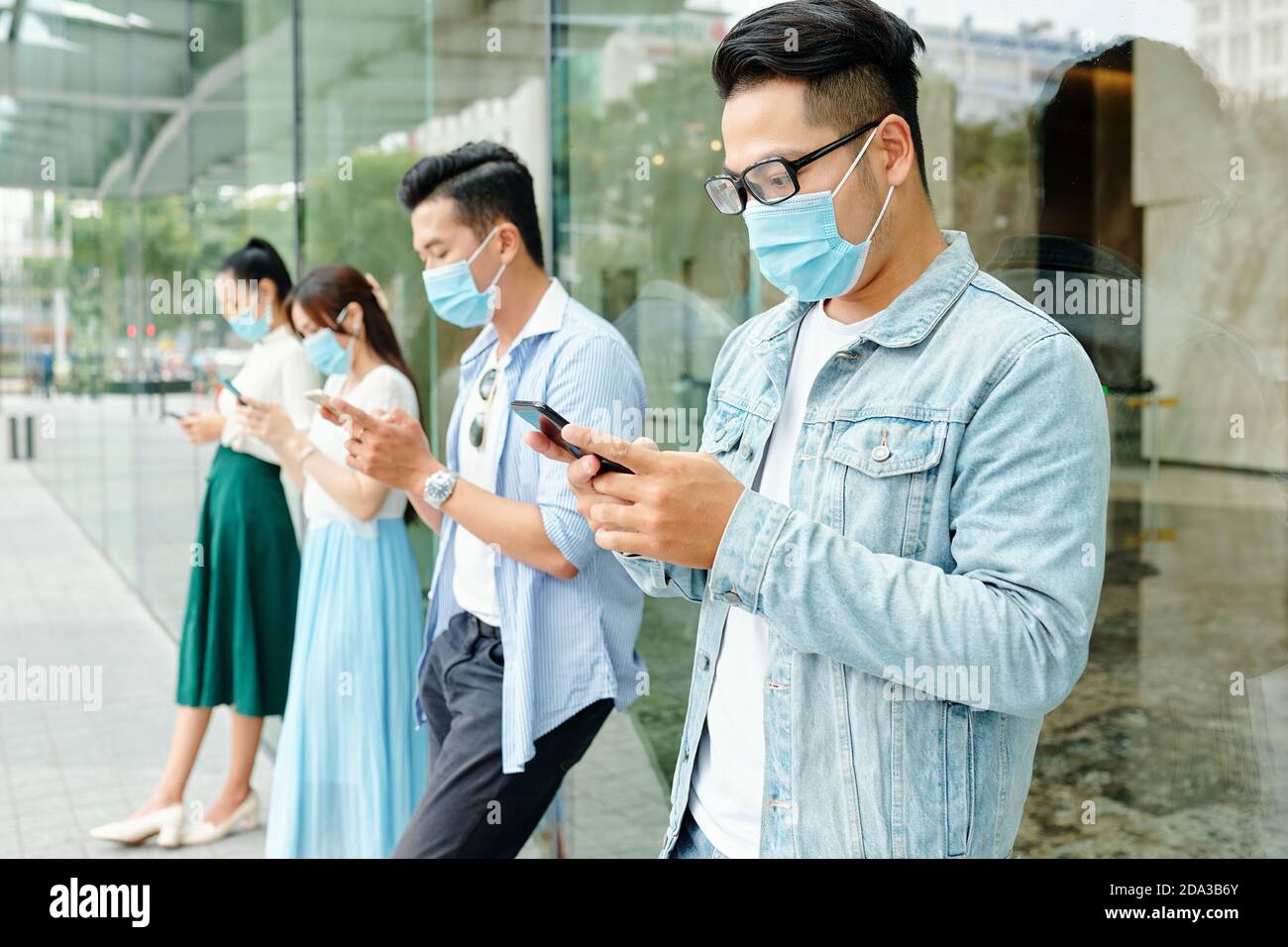 Young people texting friend Stock Photo - Alamy