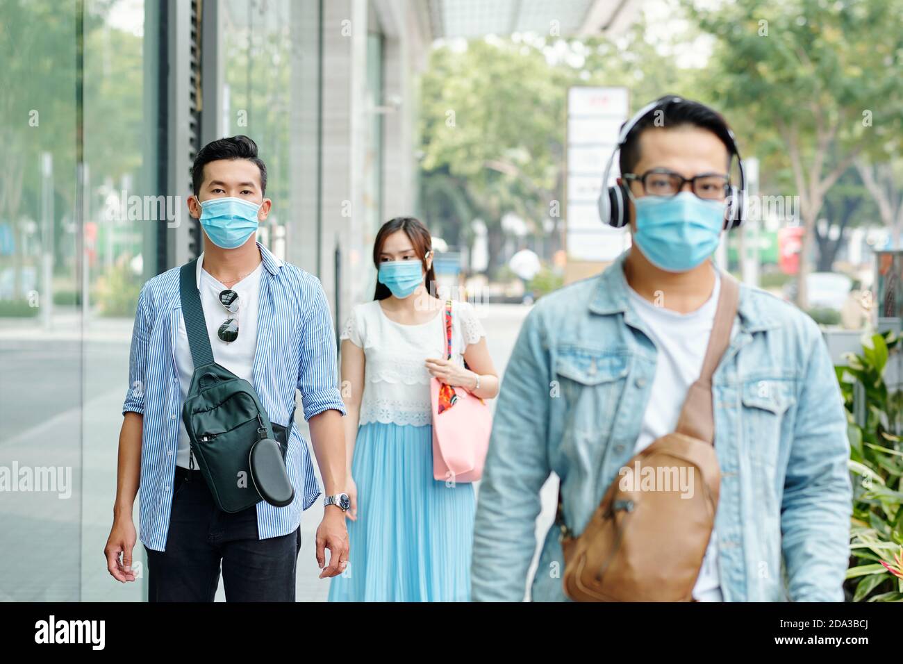 People in masks walking in city streets Stock Photo - Alamy