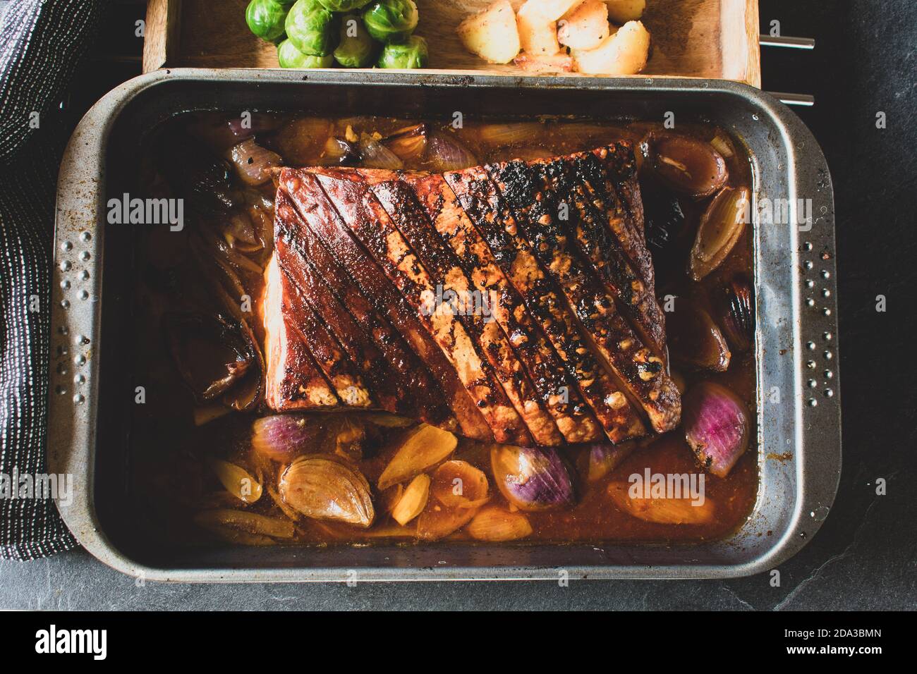 Rustic roast pork meal with roasted pork belly and crust served in a ...