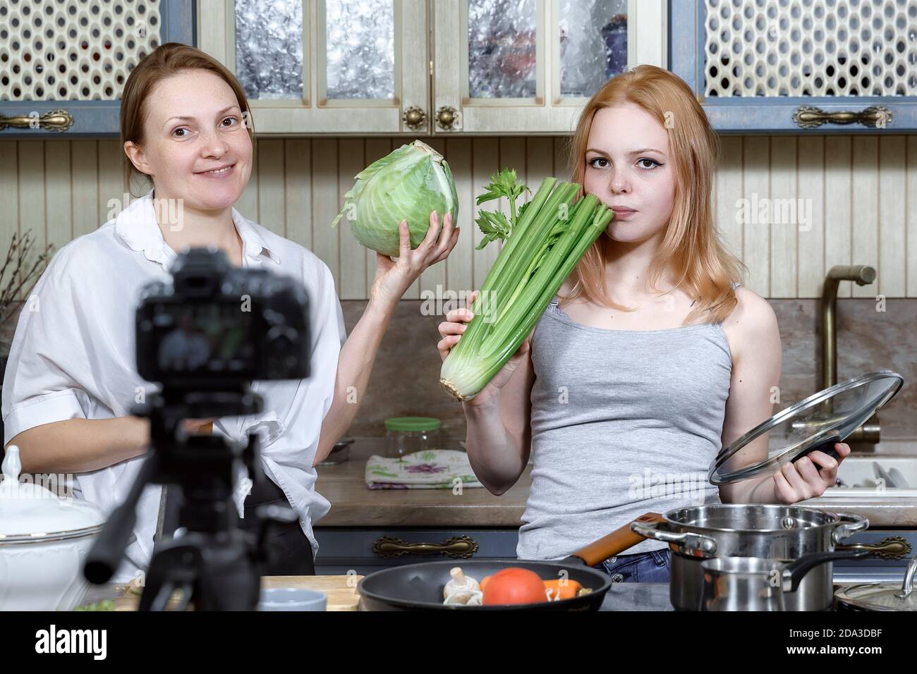 mom and daughter are recording a funny cooking show. food vlogging ...