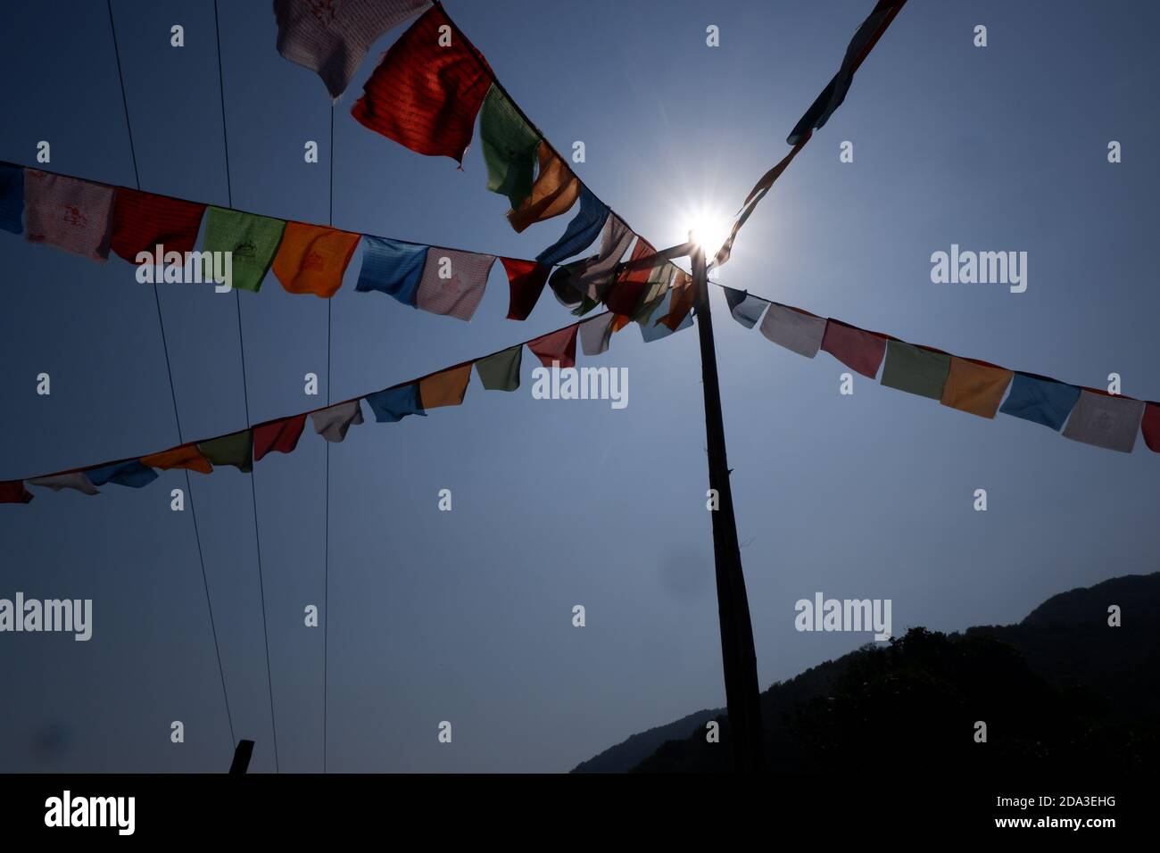 Colour fabric flags hanging in local village under bright sunlight ...