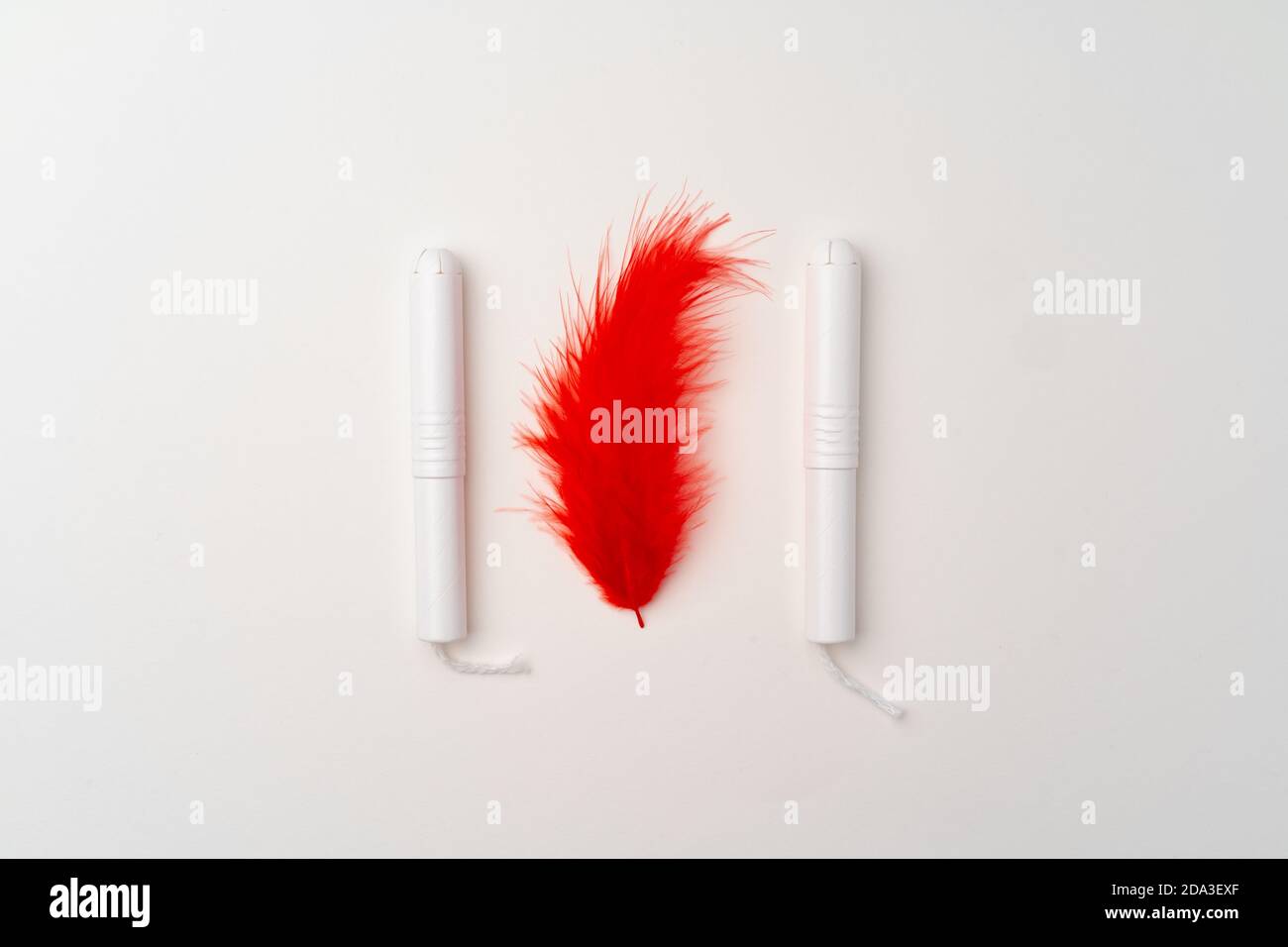 Red feather and woman medical tampon on white background Stock Photo ...
