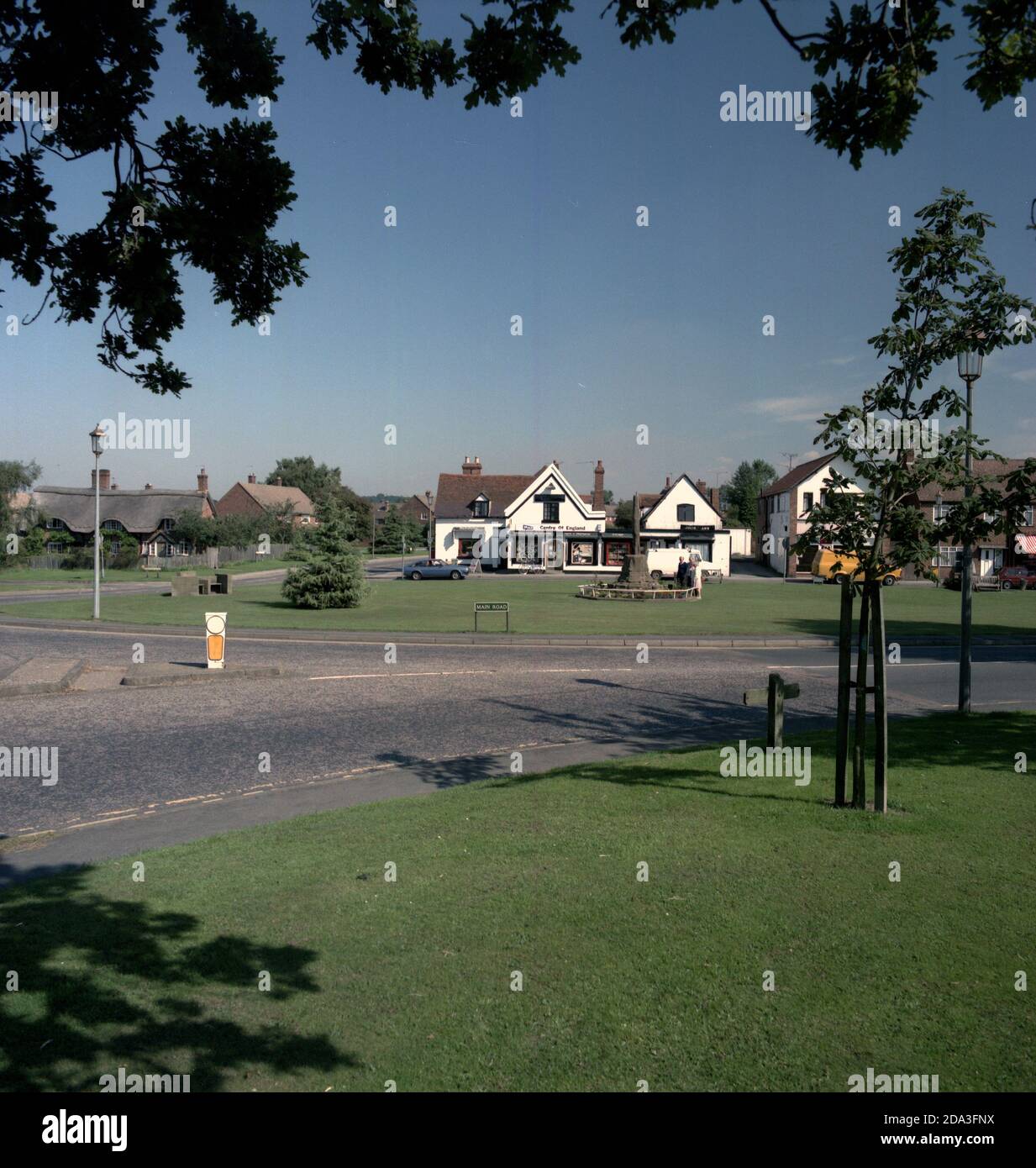 The Meriden Cross on the village green with a thatched cottage on the ...