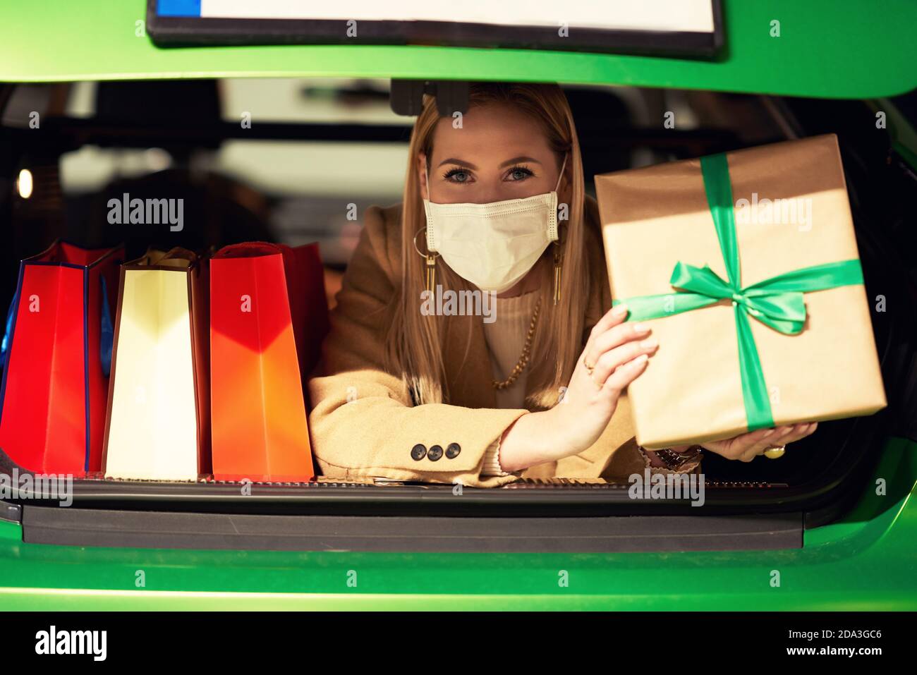 Adult woman with shopping bags in mask lying in trunk Stock Photo - Alamy