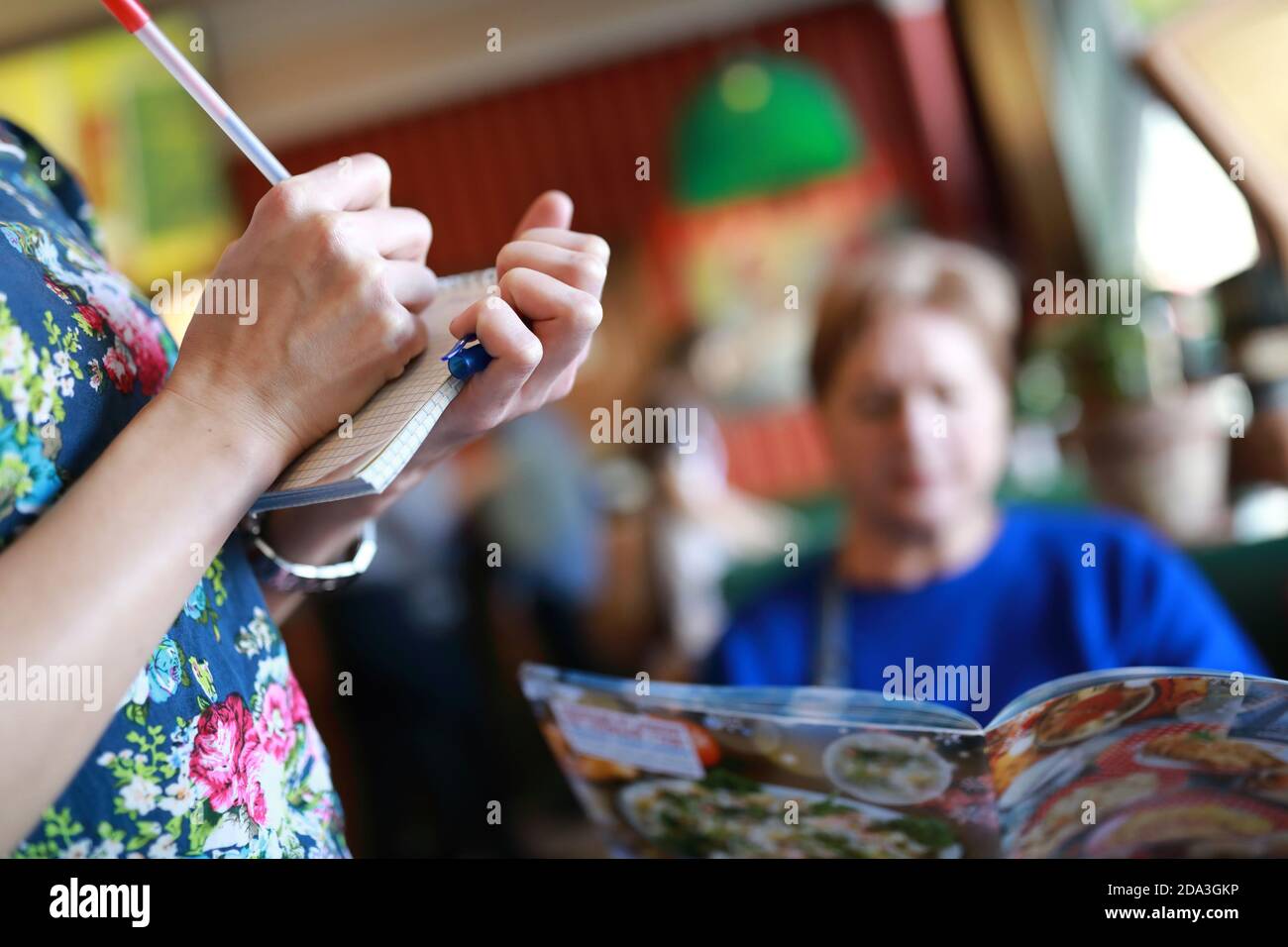 Waitress writes names of dishes in notebook in restaurant Stock Photo ...