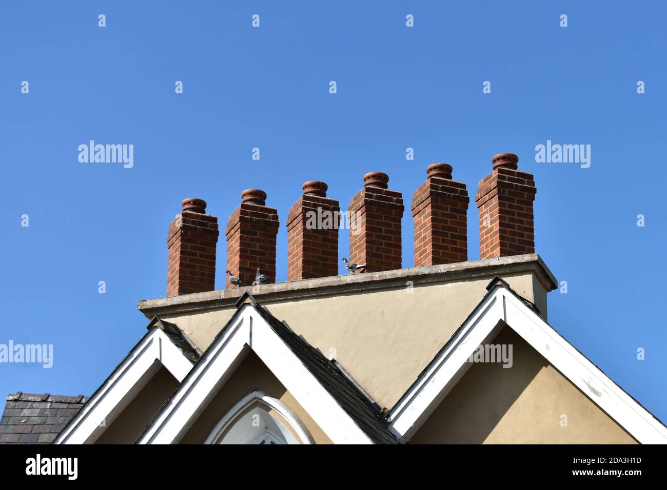 close up of 6 unusual attractive brick built chimneys sitting on house ...
