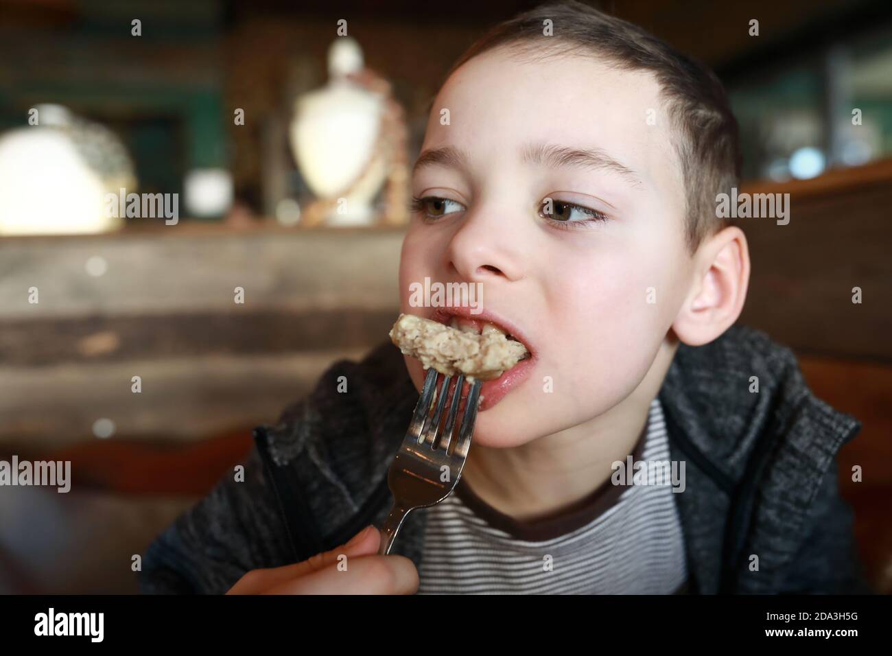 Boy eats chicken cutlet in a restaurant Stock Photo - Alamy
