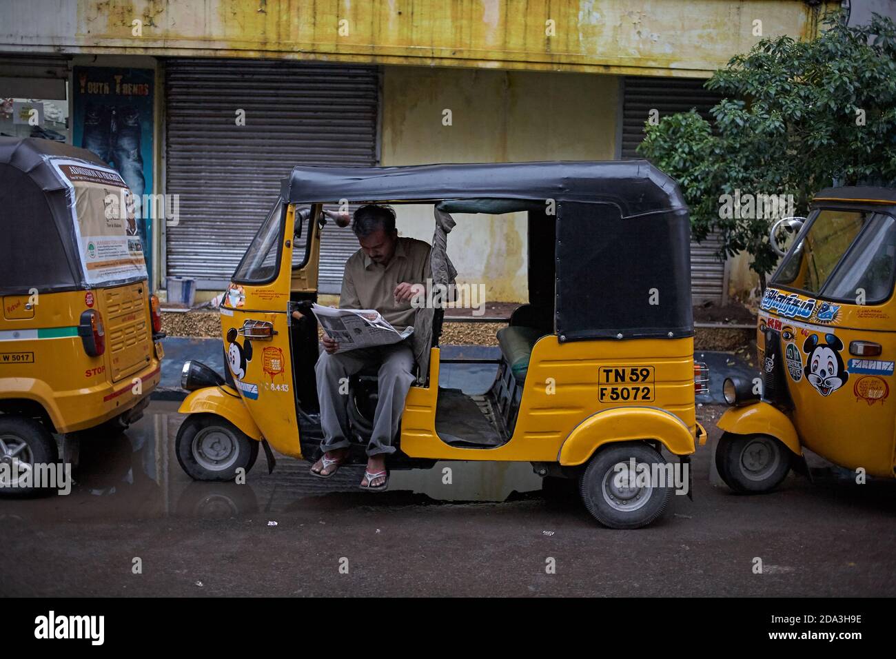 Madurai, India, April 2012. A rickshaw driver reading the newspaper ...