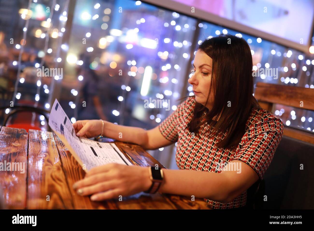 Woman reading menu book in a pub Stock Photo - Alamy