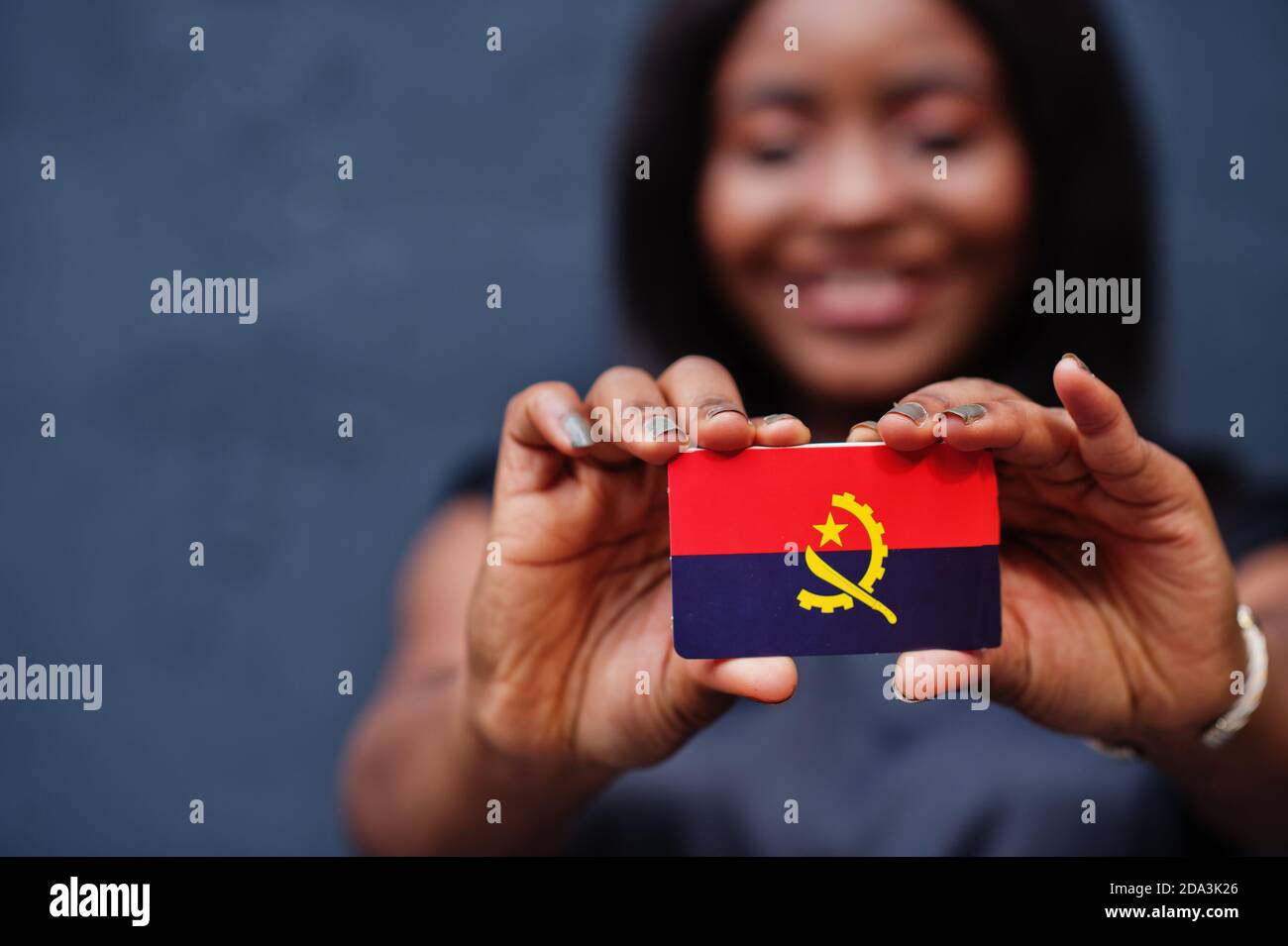 African woman hold small Angola flag in hands Stock Photo - Alamy