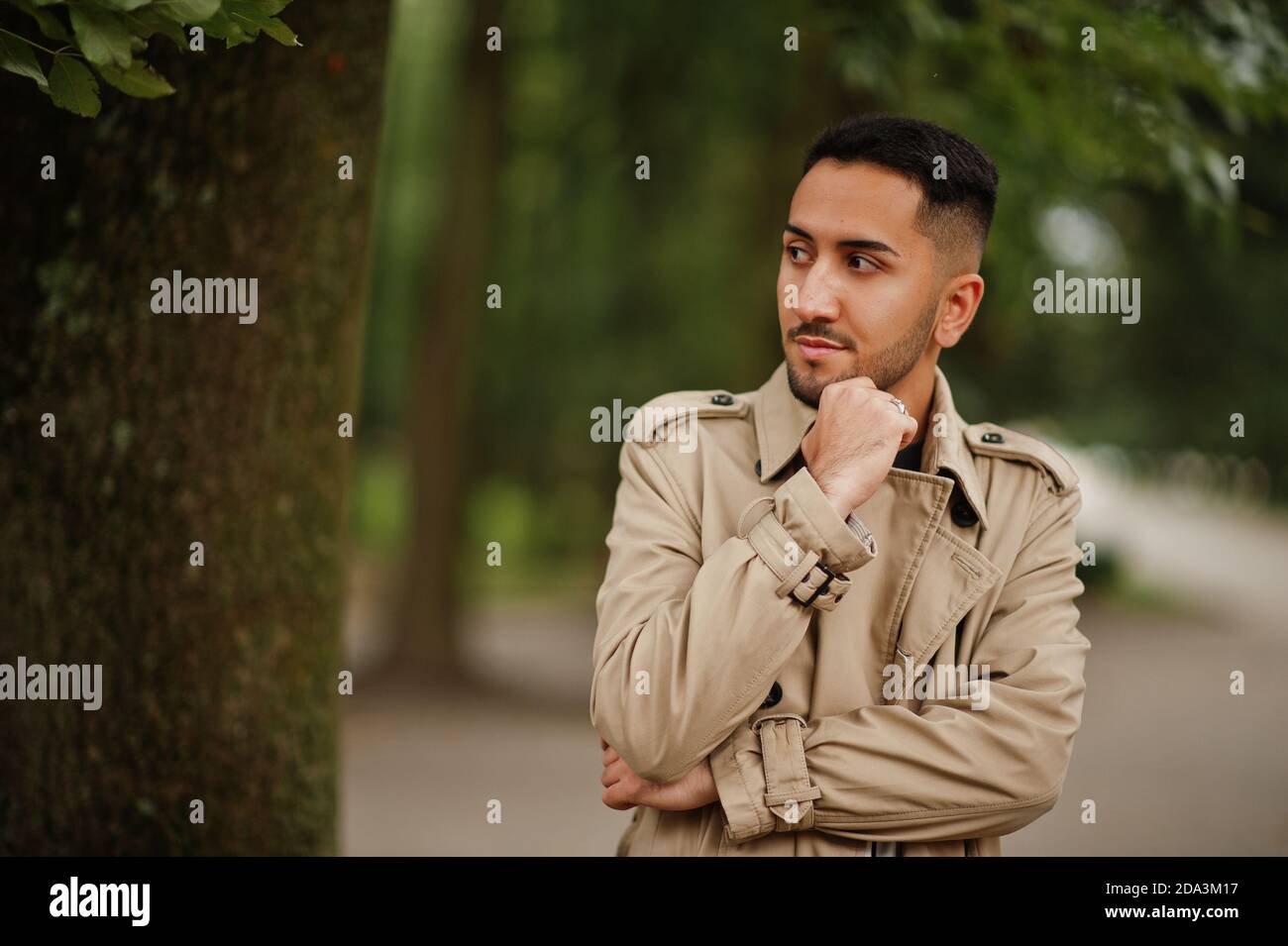 Stylish kuwaiti man at trench coat walking at park Stock Photo - Alamy