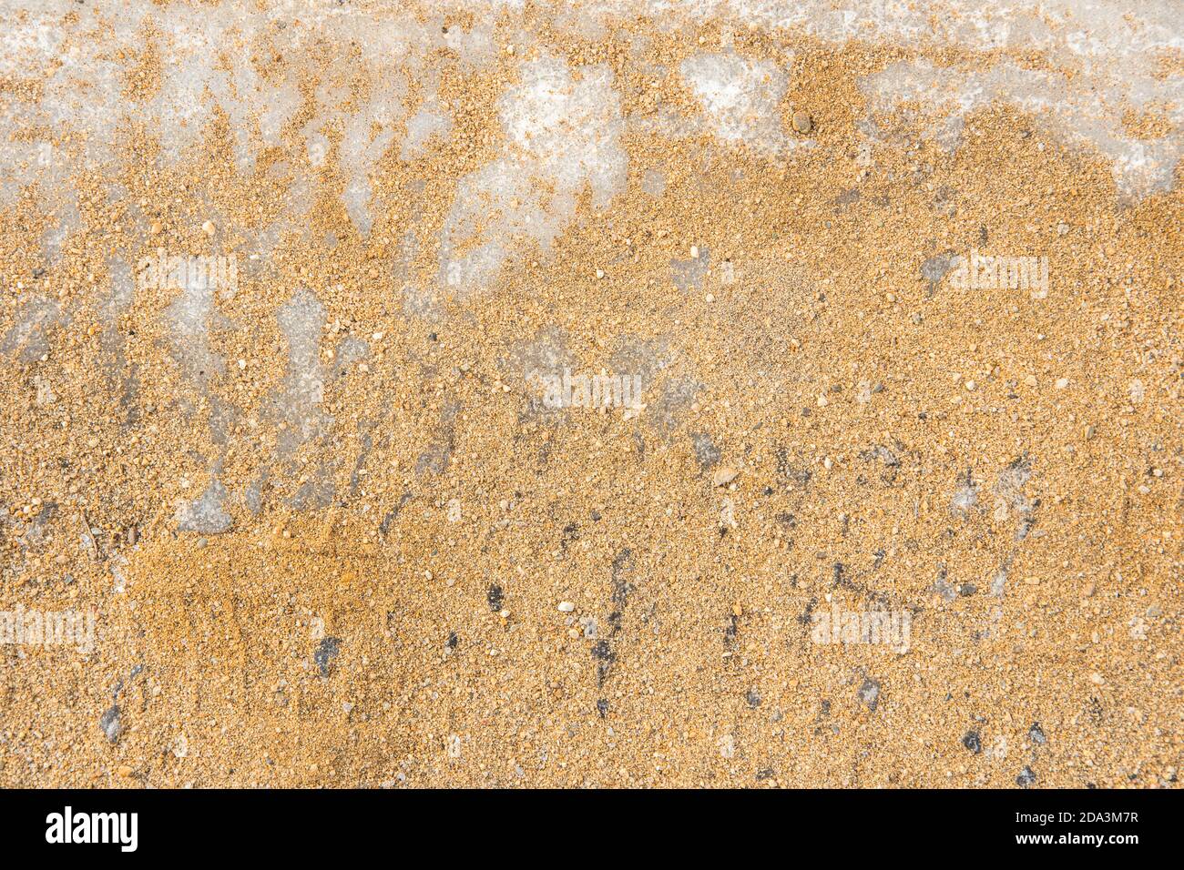 Texture of yellow sand on white ice. Sand is poured onto ice for safe ...