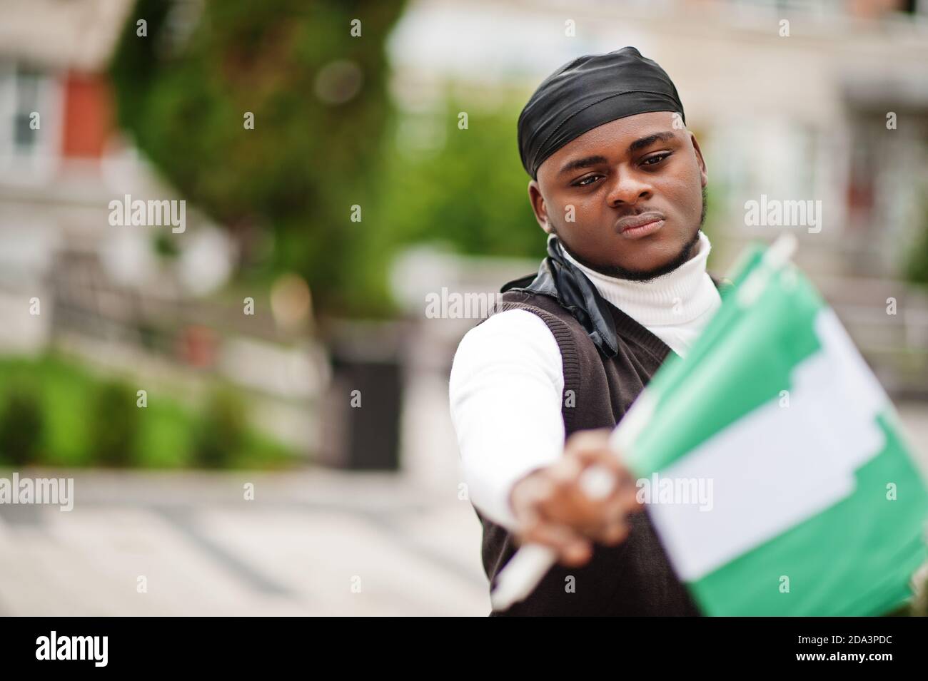 Young african american man hold nigerian flags in hands Stock Photo - Alamy