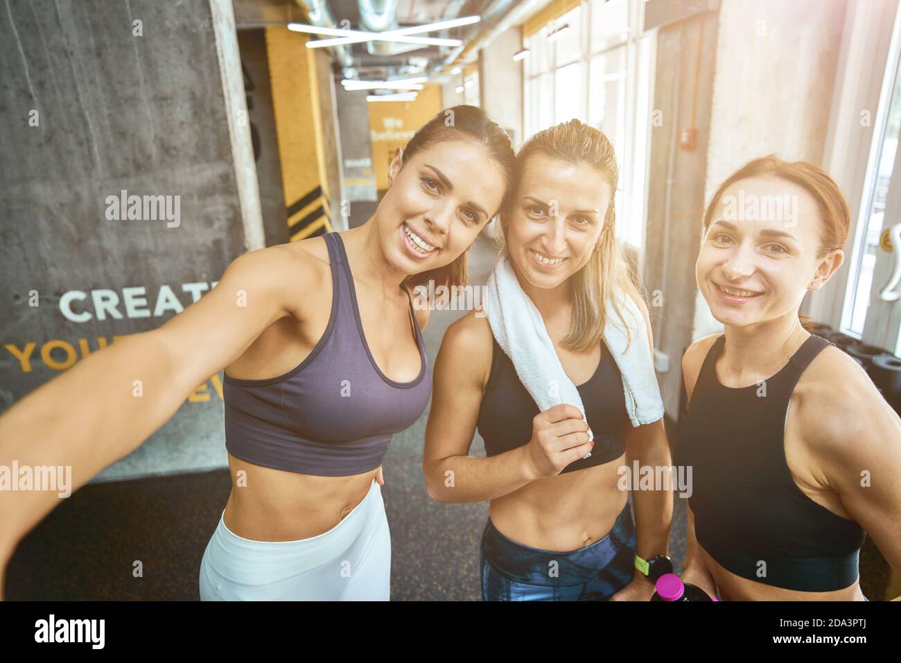 Working out with friends. Group of three young sportive women taking ...
