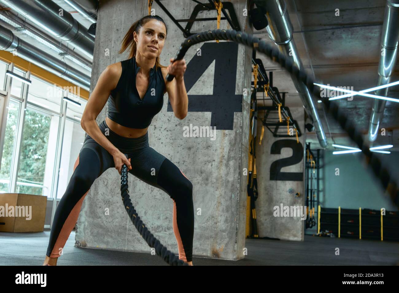 Working hard. Young strong athletic woman wearing sport clothes ...