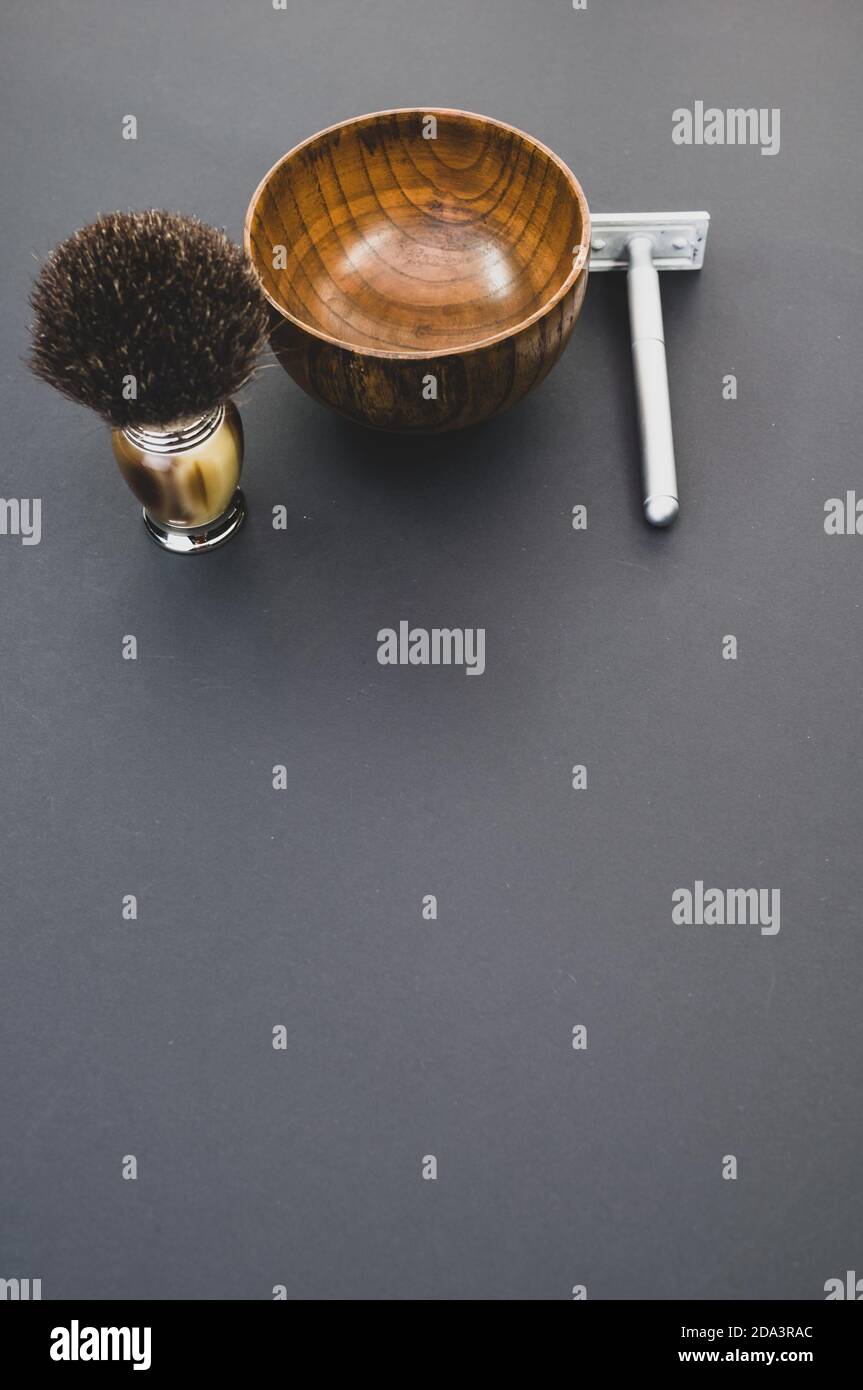 High angle shot of a wooden shaving water bowl near a shaving brush and ...