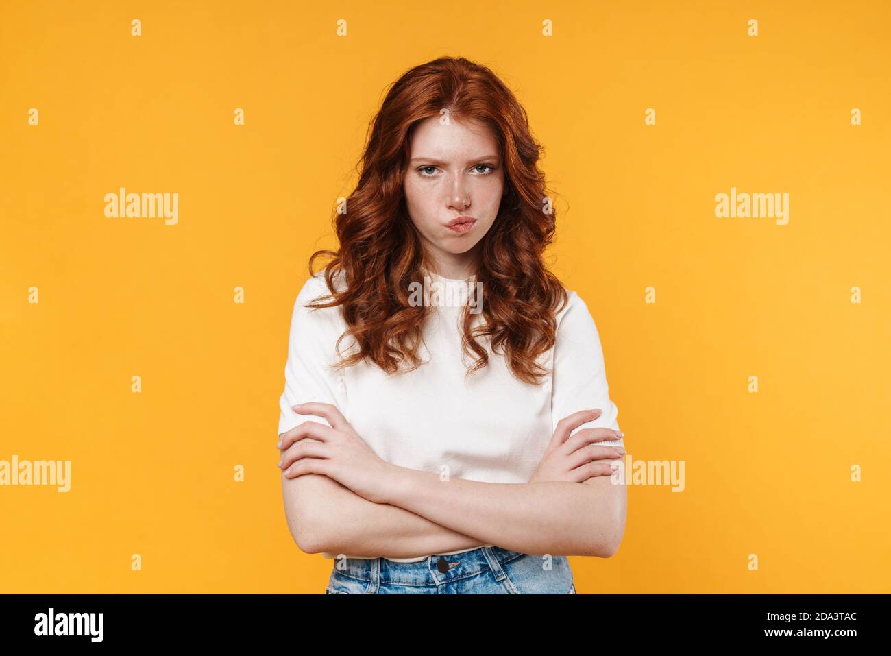 Image of ginger displeased girl posing on camera with arms crossed ...