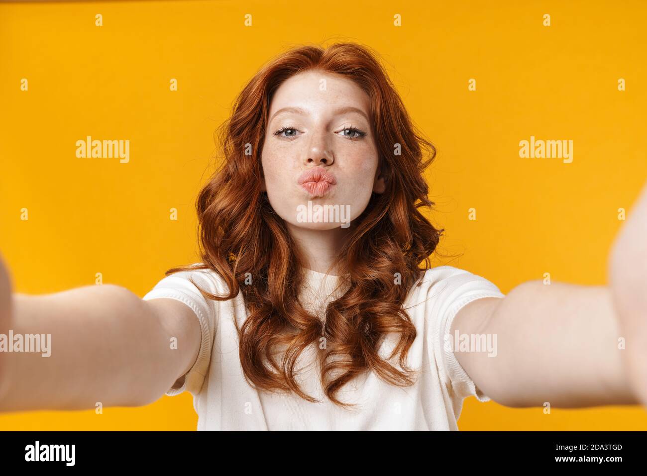Image of redhead cheerful girl making kiss lips and taking selfie photo ...