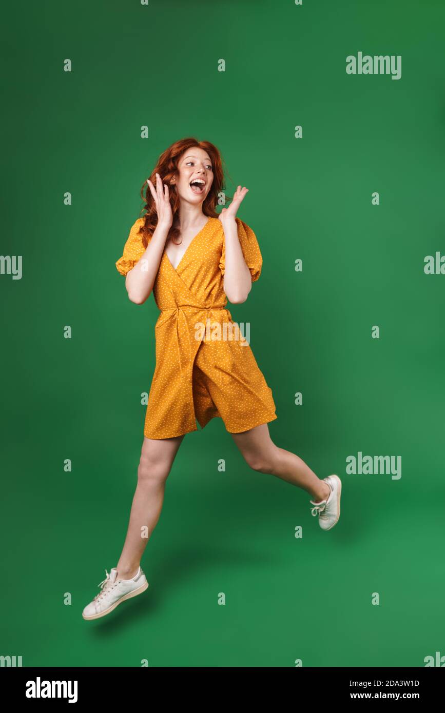 Image of ginger excited girl screaming and running isolated over green ...
