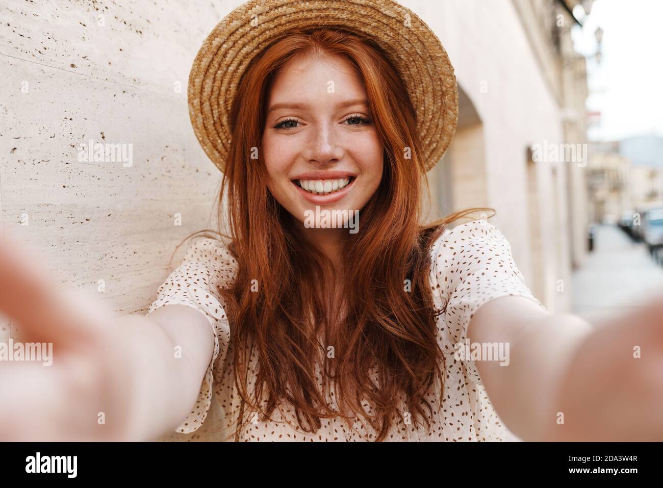 Image Of Joyful Ginger Girl In Straw Hat Smiling While Taking Selfie