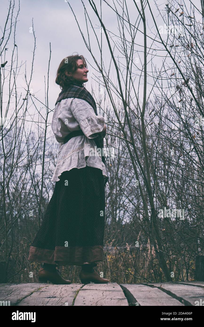 A young woman in an ancient headscarf stands on a dais near an old ...