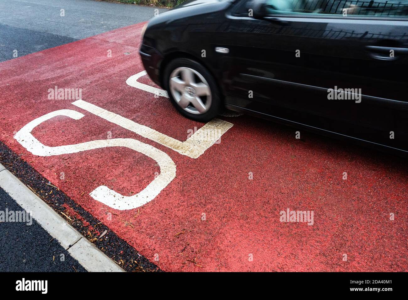 slow sign written on the road with passing car Stock Photo - Alamy