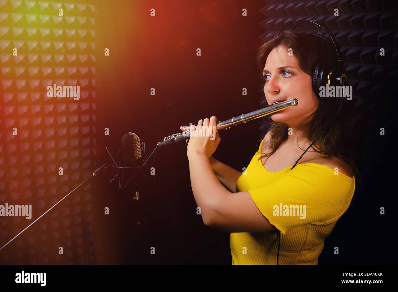 Woman flutist playing the silver flute. Record wind musical instruments ...