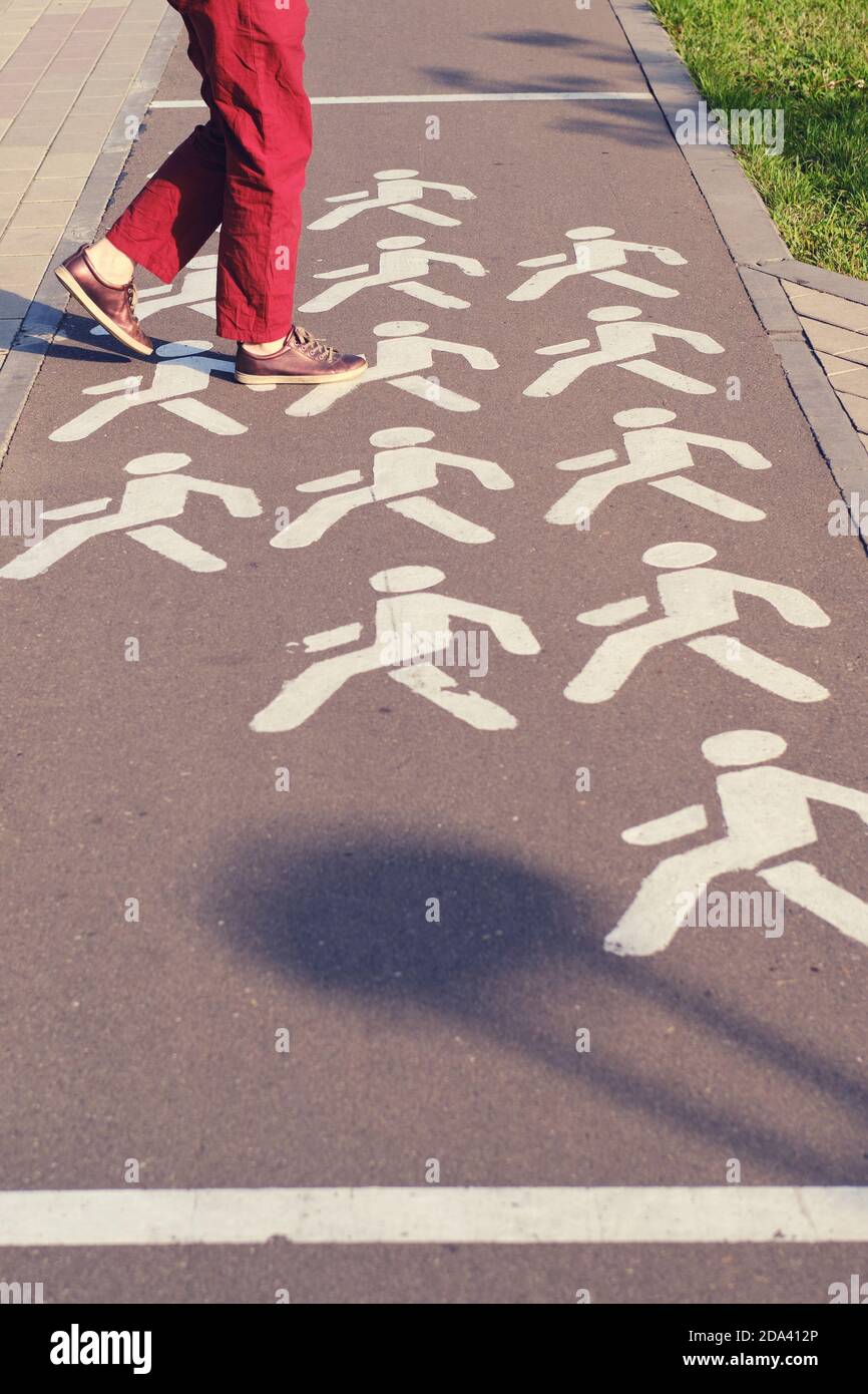 Woman crosses a bike path in a park at a pedestrian crossing Stock ...