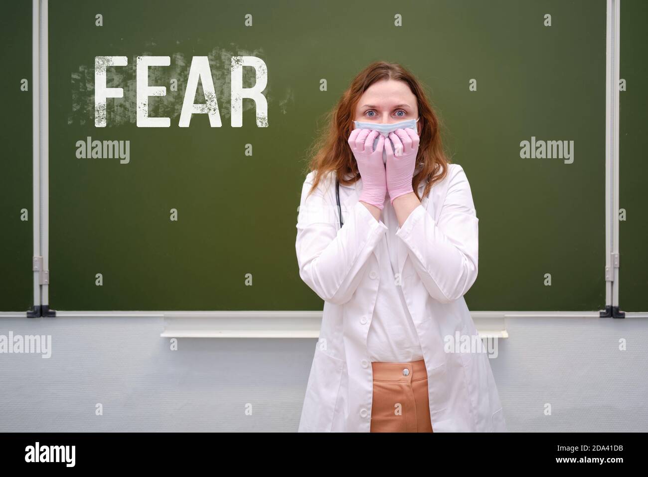 Scared doctor in medical mask in school class. School quarantine ...