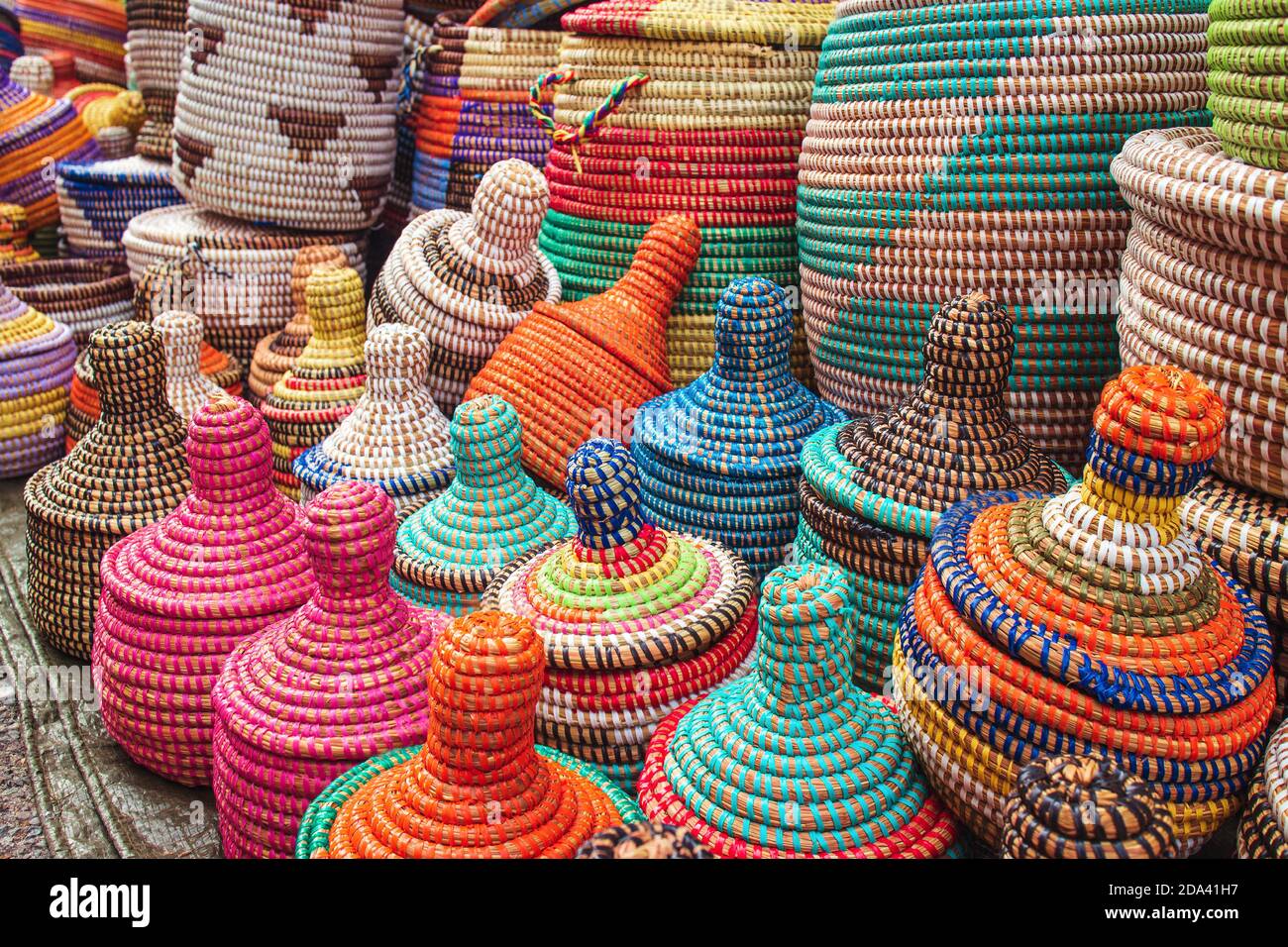 many african straw baskets on a market stand, with many colors and ...