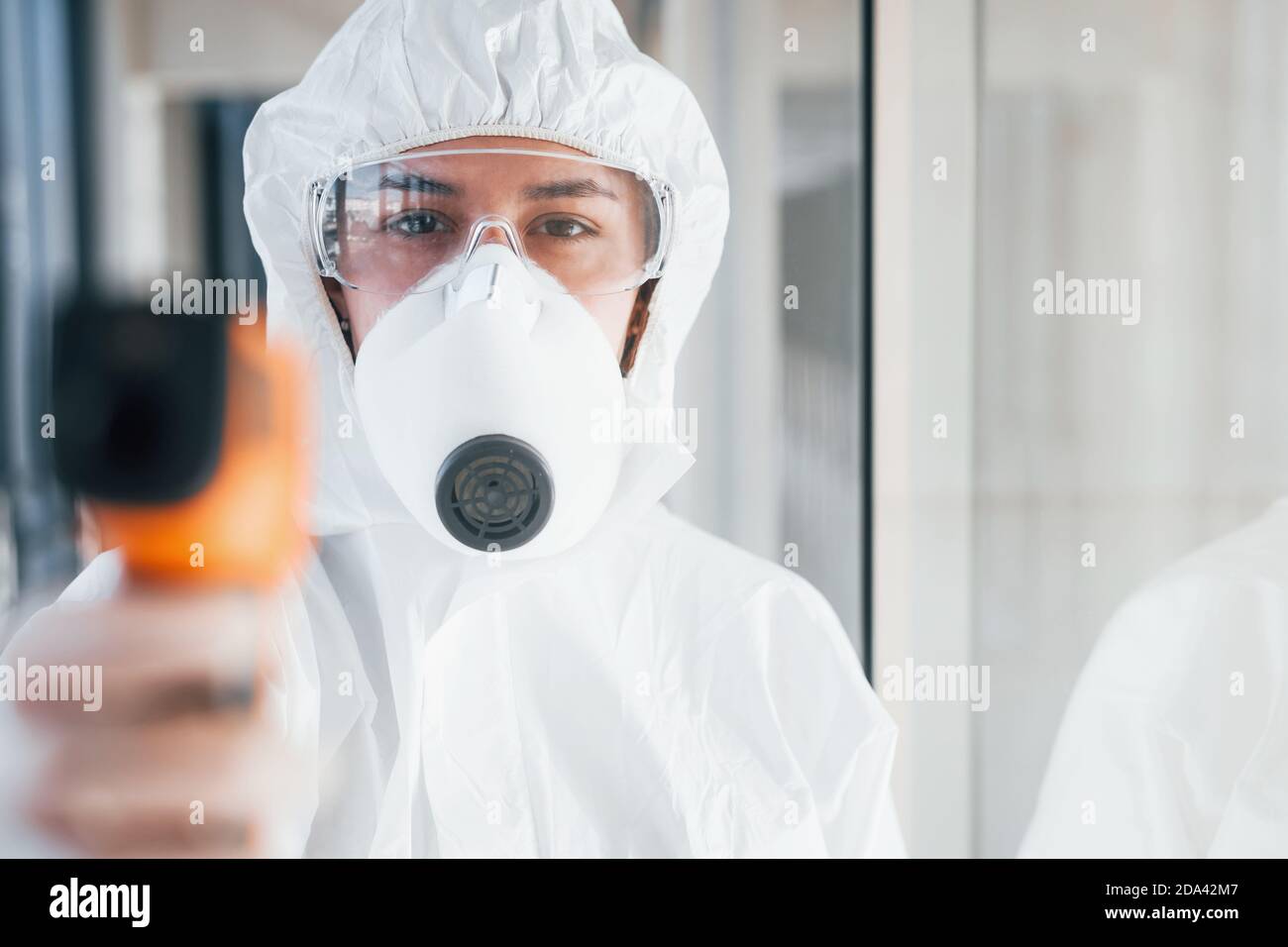 Female doctor scientist in lab coat, defensive eyewear and mask ...