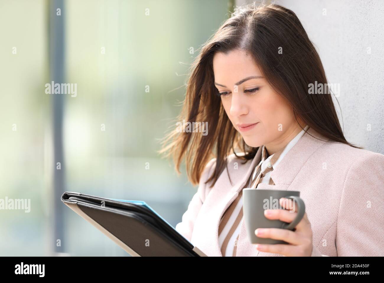 Business woman reading report at coffee break standing in the street ...