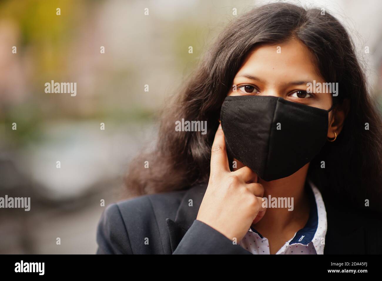 Gorgeous indian woman wear formal and black face mask, posing at street ...