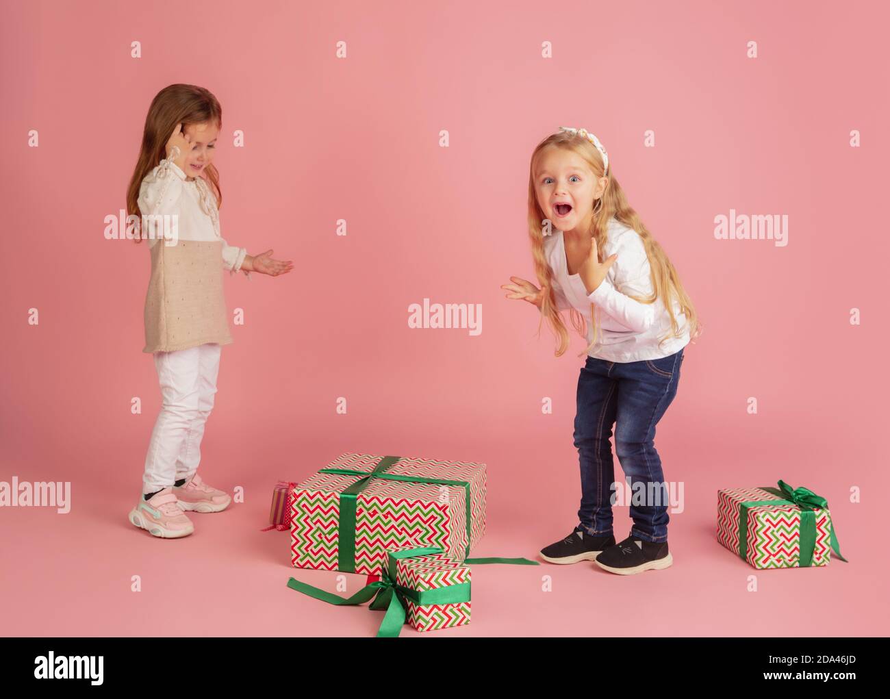 Giving and getting presents on Christmas holidays. Two little smiling ...