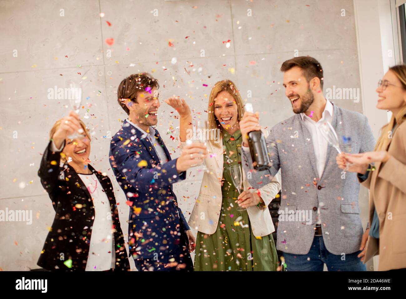 Group of excited business people celebrating and toasting with confetti ...