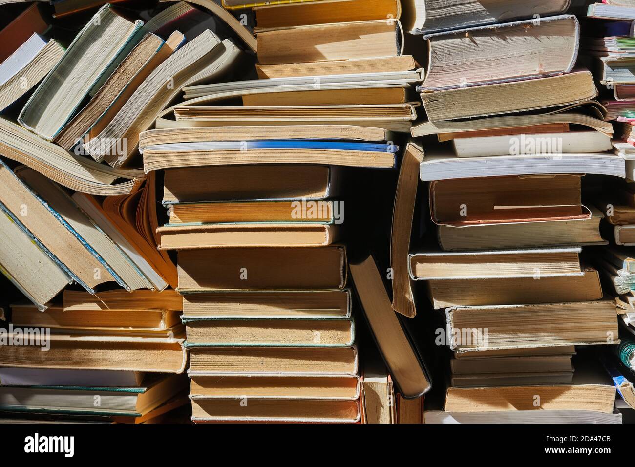 Wall of books piled up Stock Photo - Alamy