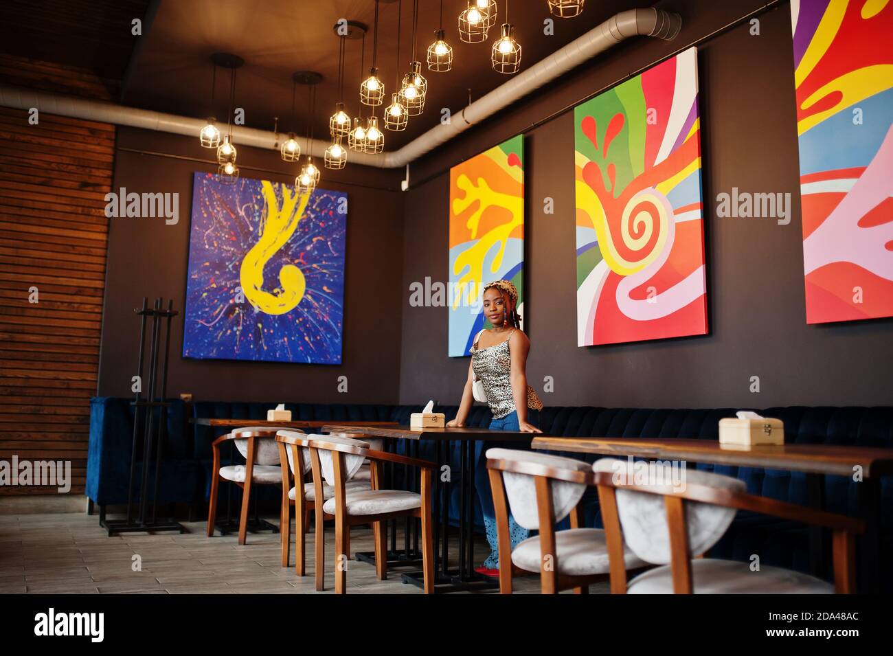 Lovely african american woman with dreadlocks in leopard outfit at cafe ...