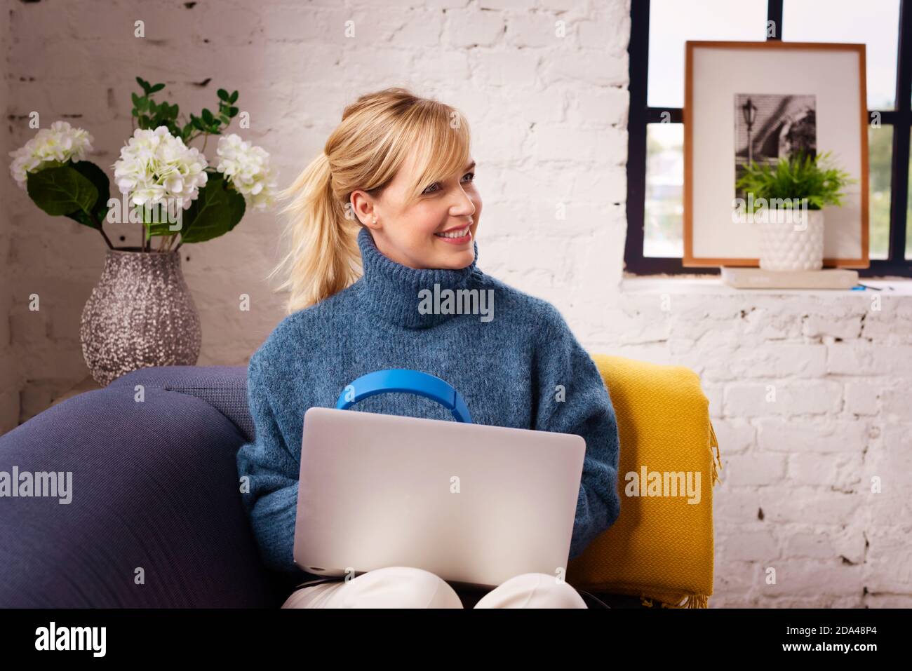 Portrait shot of beautiful smiling woman with headphonein her hand ...