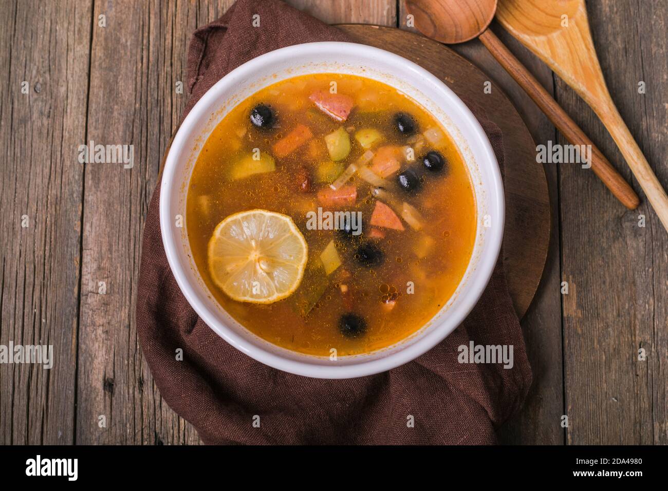 Slavic Solyanka soup in a white bowl on dark wooden background with ...