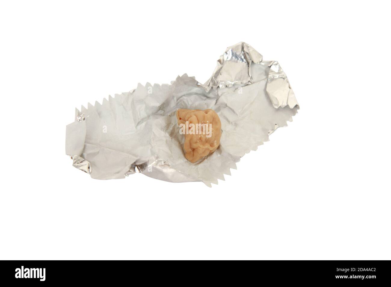 Closeup of a chewed gum on a crumpled foil bubblegum packaging isolated ...
