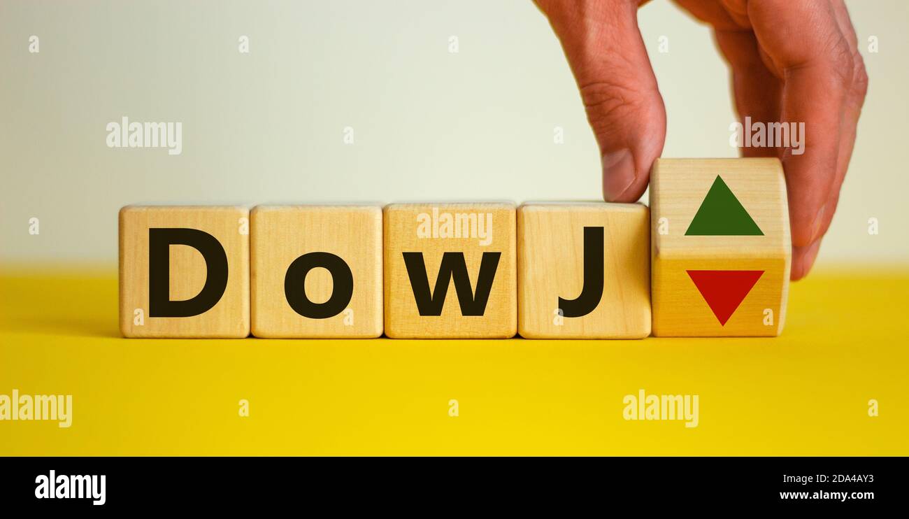 Male hand flips a wooden cube and changes the inscription 'DowJ up' to ...