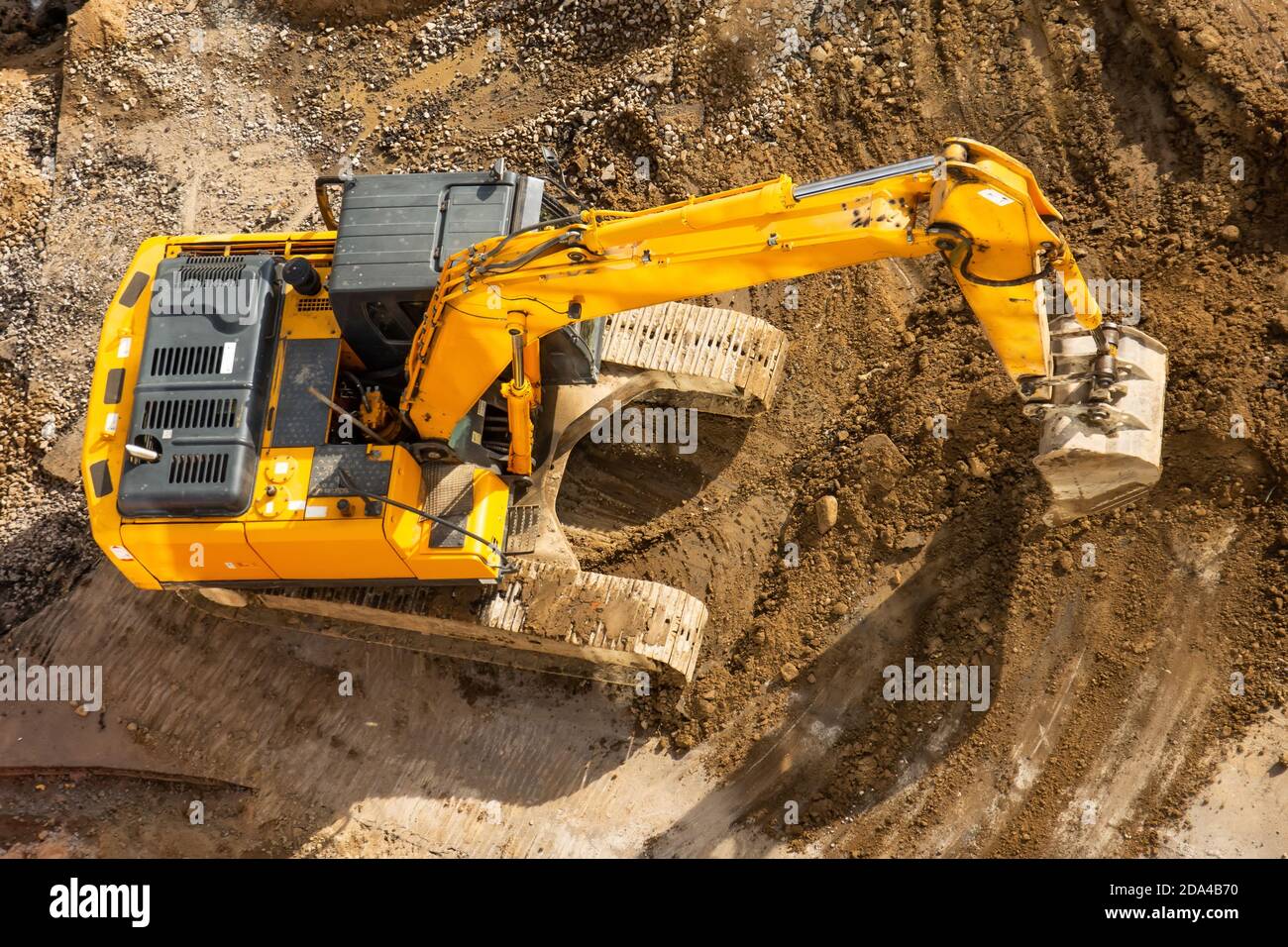 Excavator on the ground of a construction site with a raised bucket ...