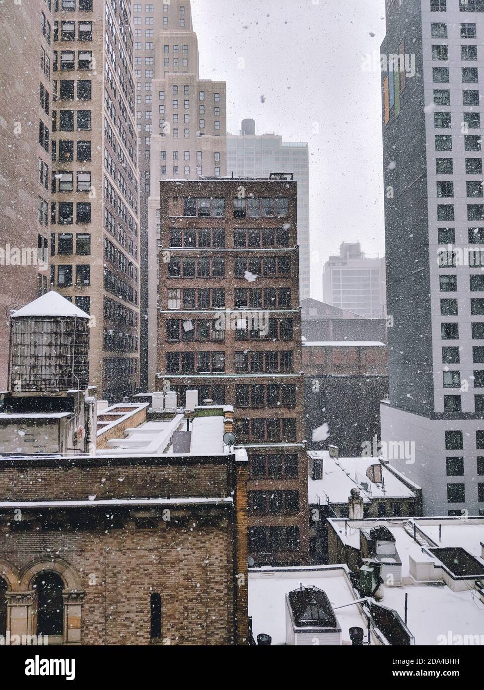 A view from a window during winter storm. Looking on buildings in ...