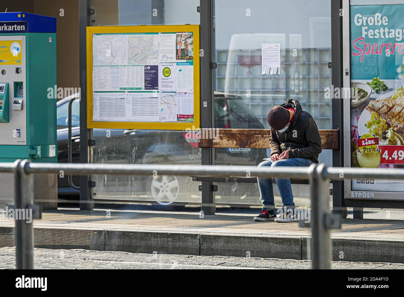 Spring 2020. Frankfurt, Germany. Bus stop with one man sitting on bench ...