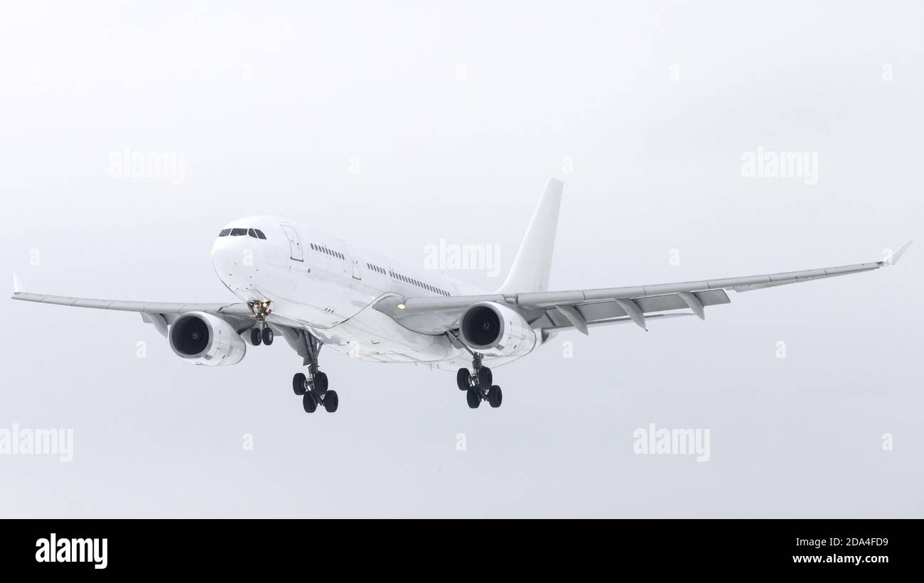 White passenger airliner with chassis in the sky, side view, landing ...